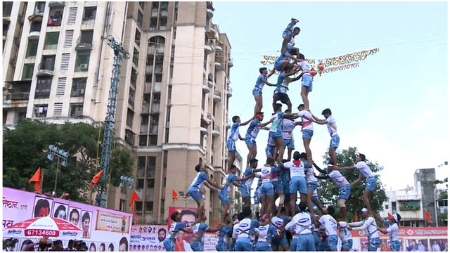 Child climbs to top of winning human tower in competition - BBC News